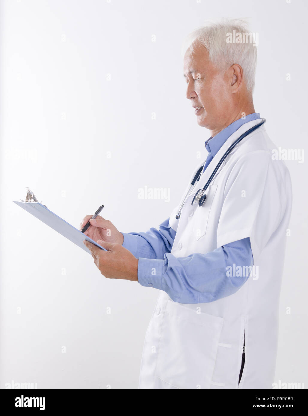 Senior Asian medical doctor writing report Stock Photo - Alamy