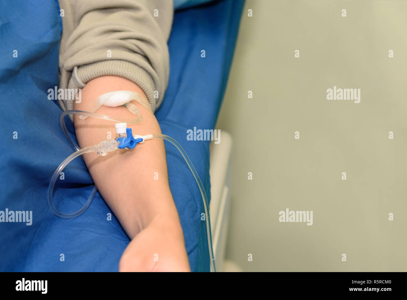 saline intravenous or iv solution with patient arm Stock Photo - Alamy