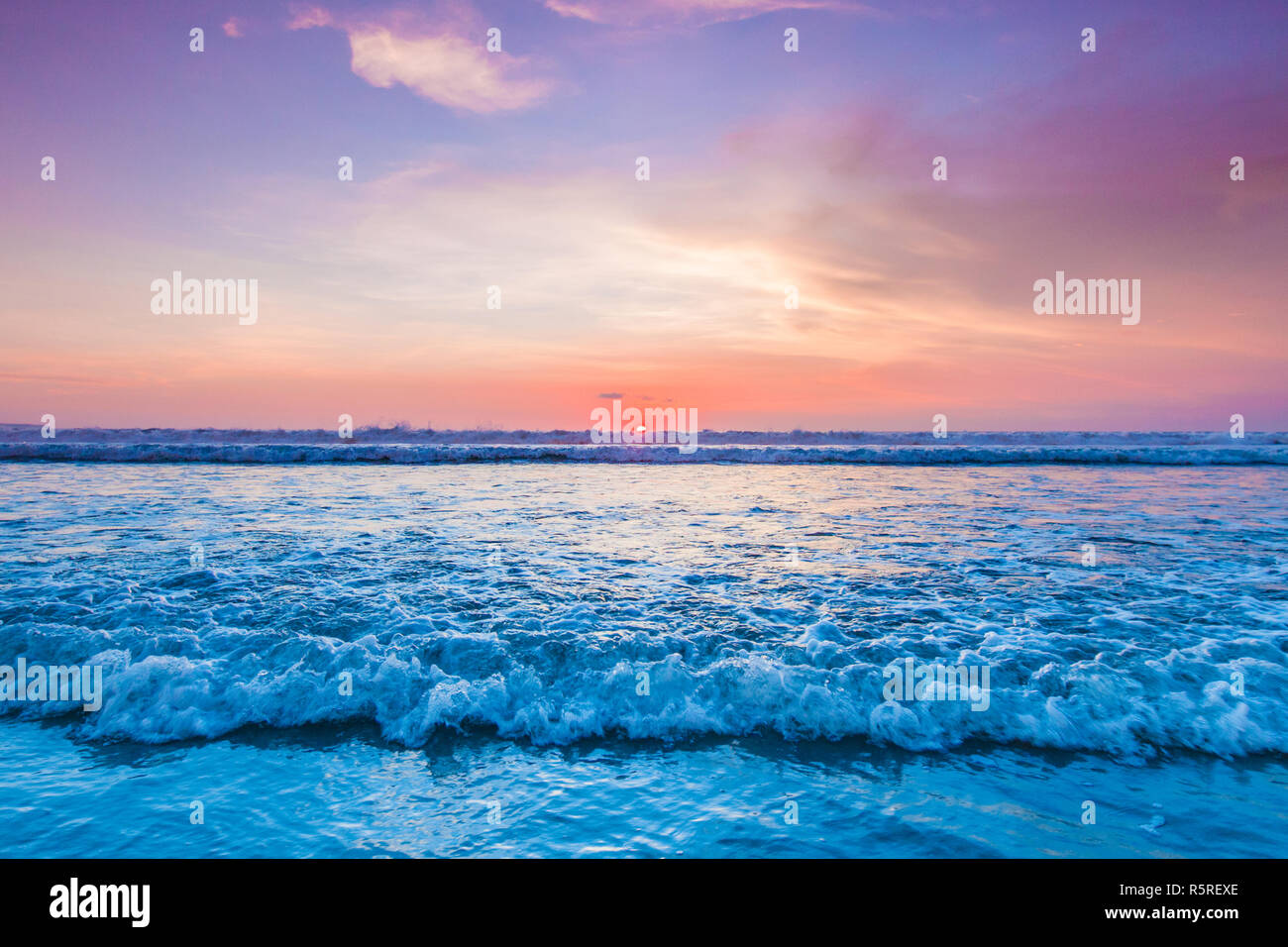 Splashing ocean wave in front of beautiful sunset sky background Stock Photo - Alamy