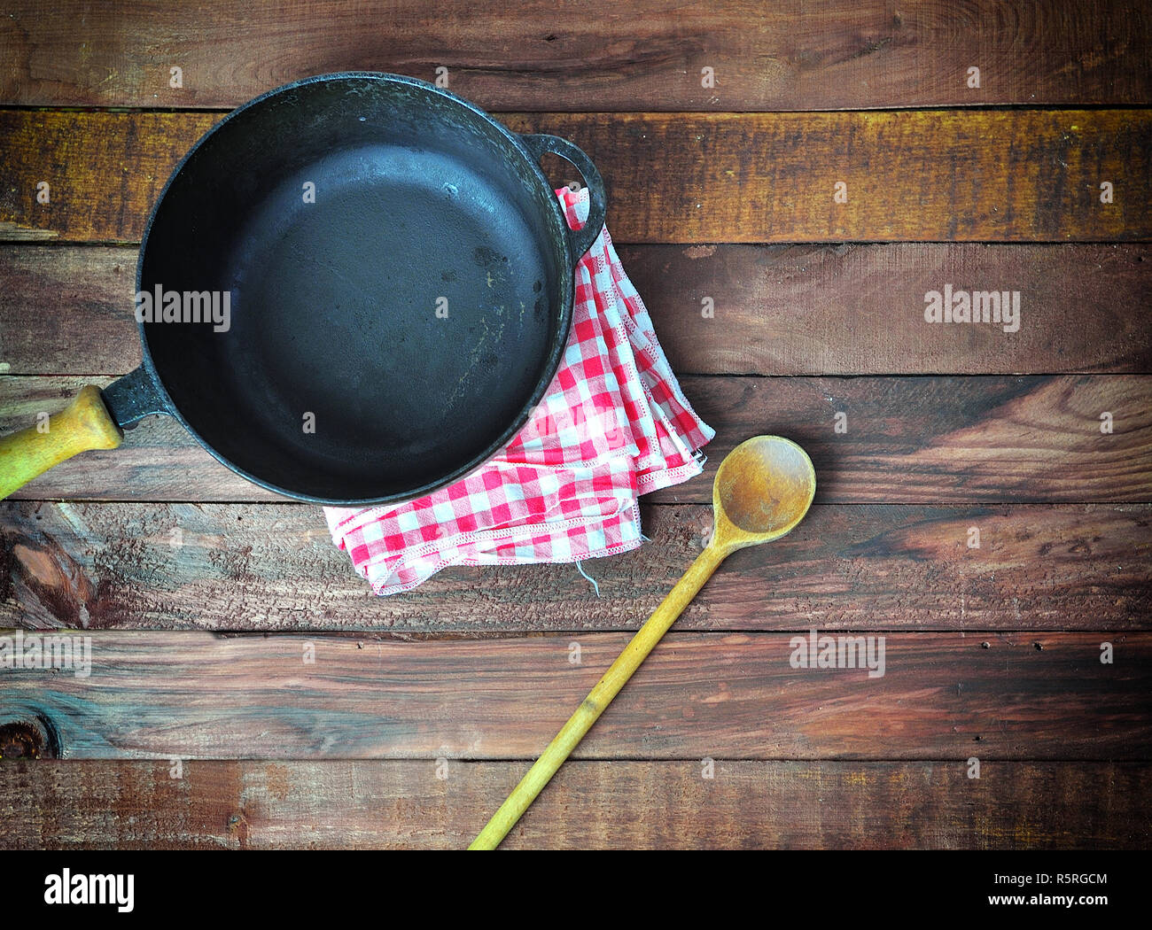 deep cast-iron frying pan with a wooden spoon, top view Stock Photo - Alamy