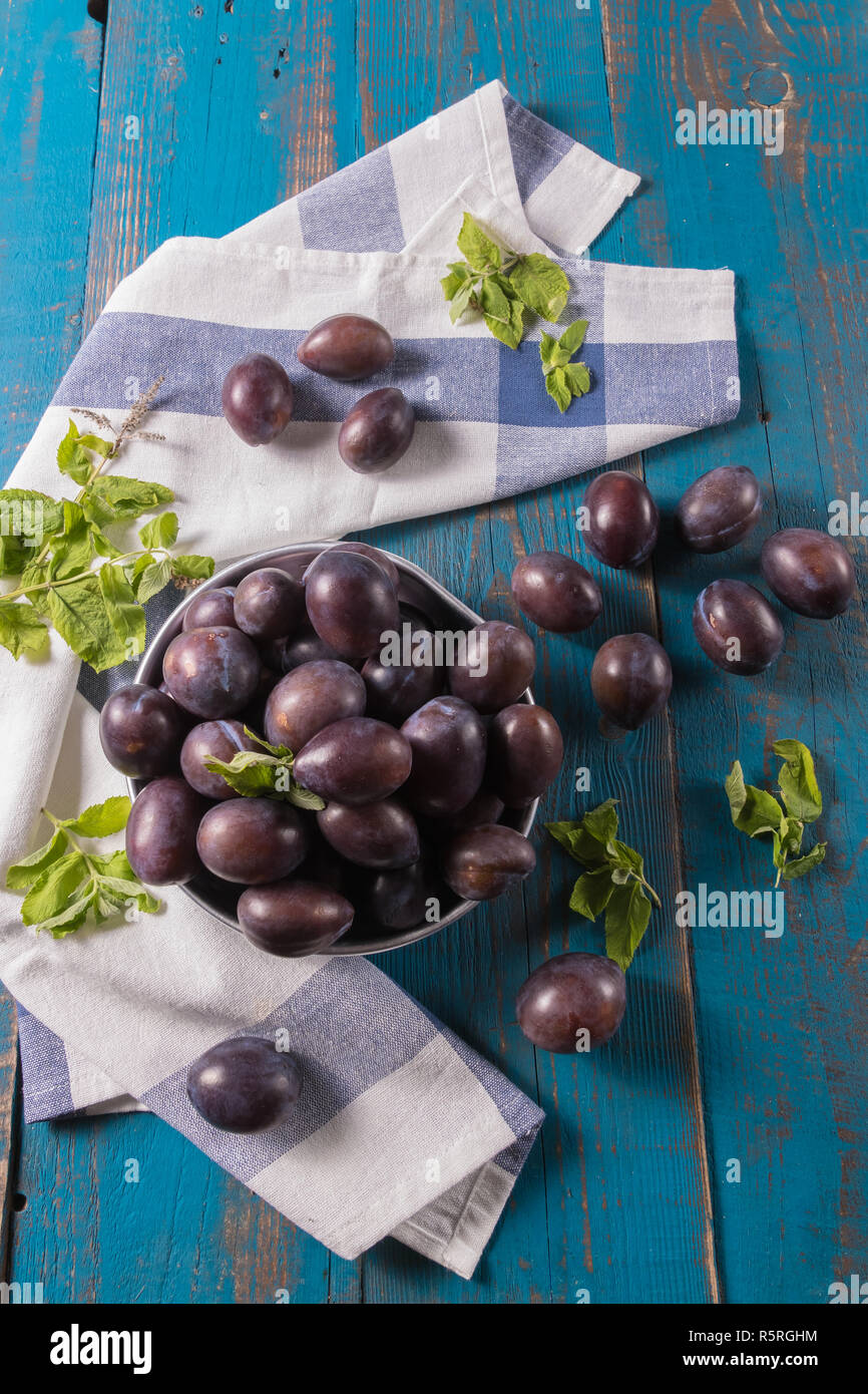Flat lay view of ripe plums, on old wooden blue background Stock Photo ...