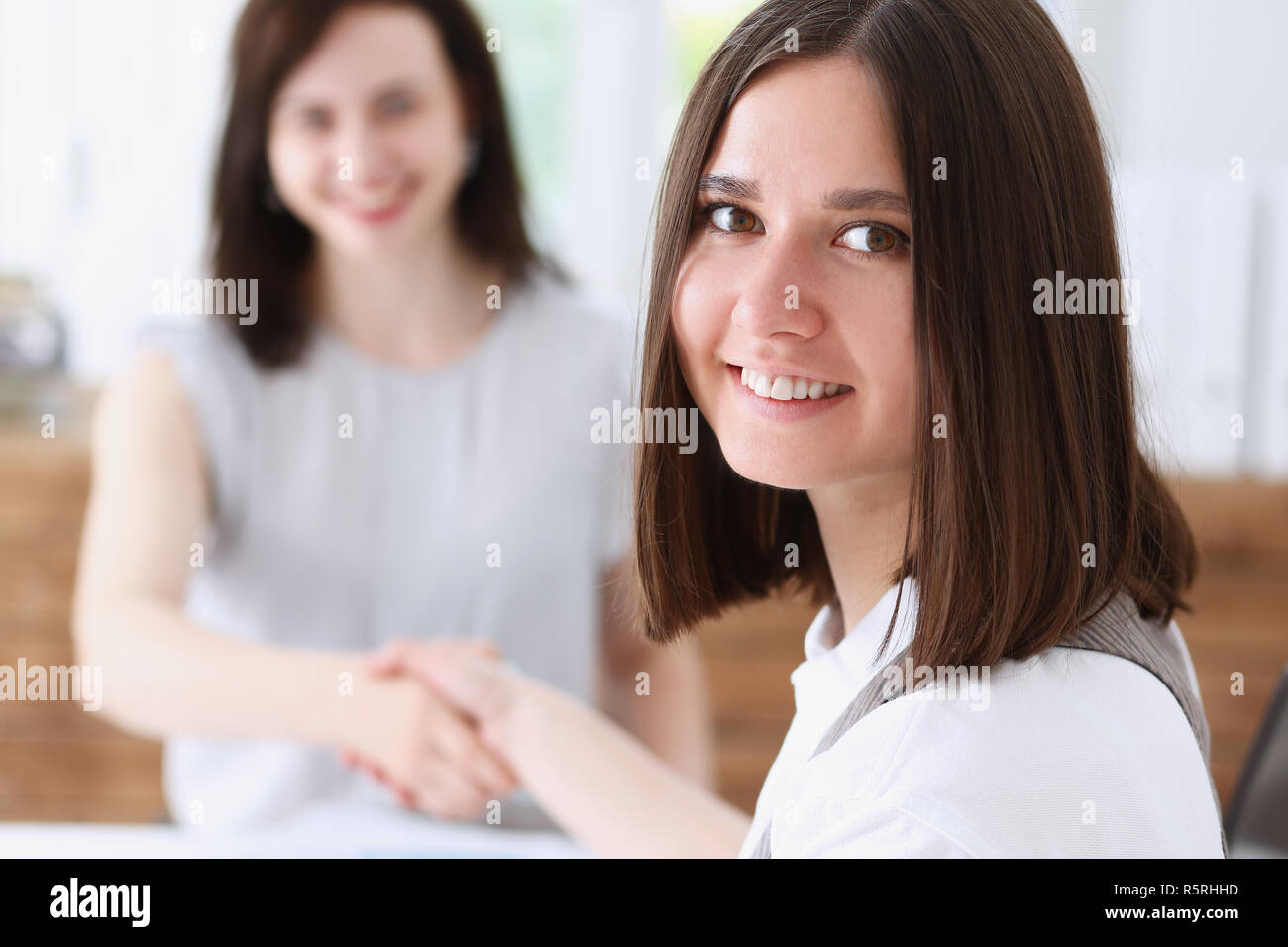 Business woman and woman shake hands as Stock Photo - Alamy