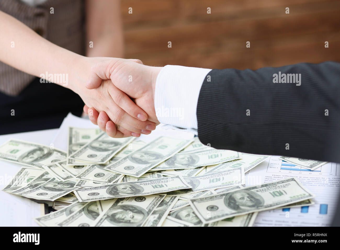 Man and woman shake hands over stack Stock Photo - Alamy