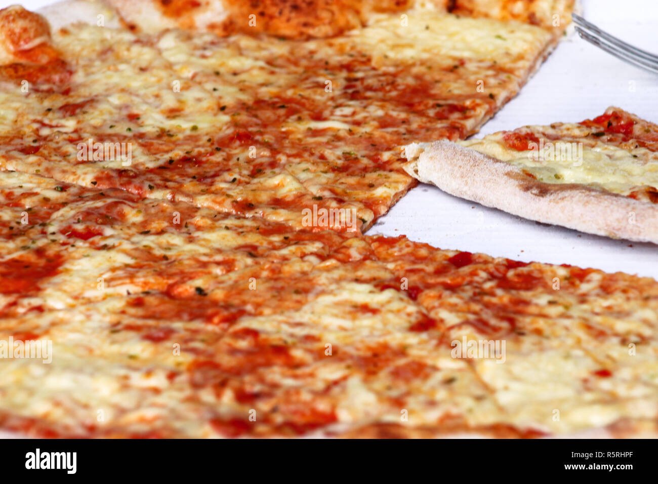 Delicious pizza Margherita and slices of pizza, fork and knife. Italian ...