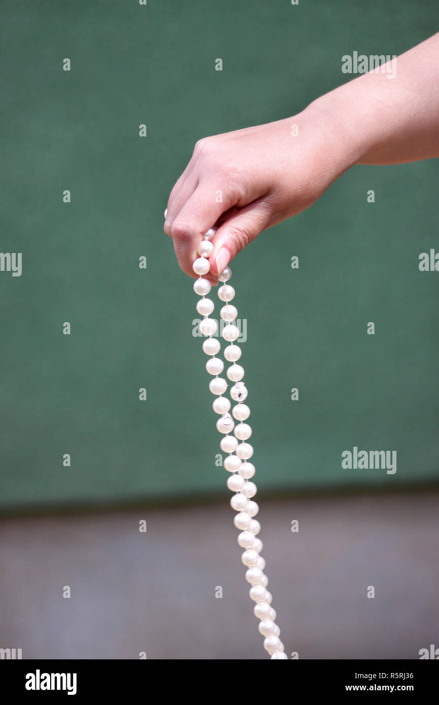 Women hands holding pearl beads jewelery. Closeup of female hand with ...