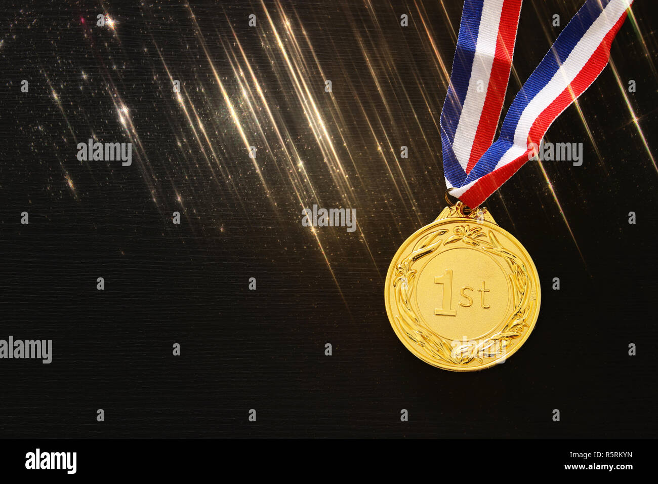 top view image of gold medal over black background. Glitter overlay ...