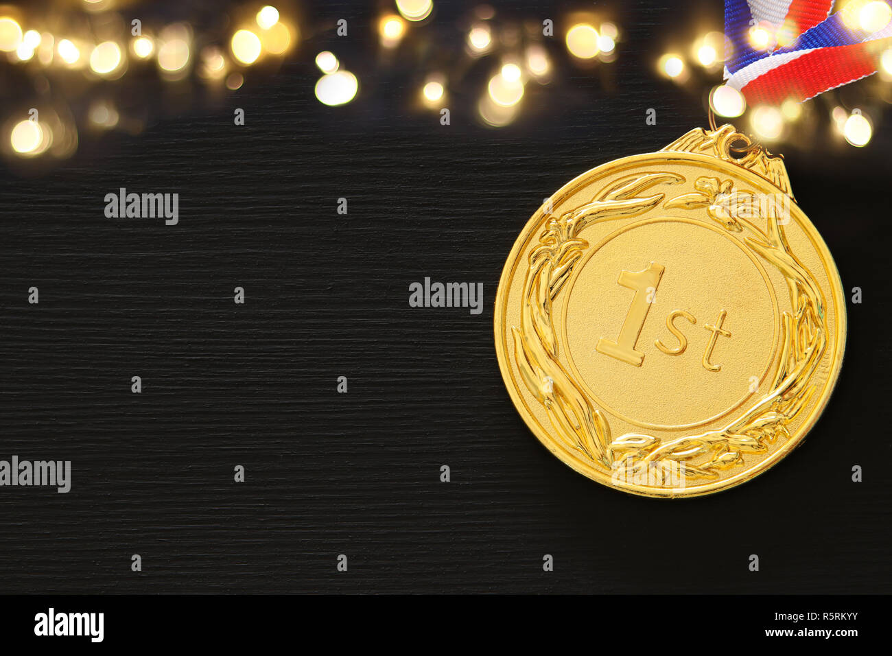 top view image of gold medal over black background. Glitter overlay ...