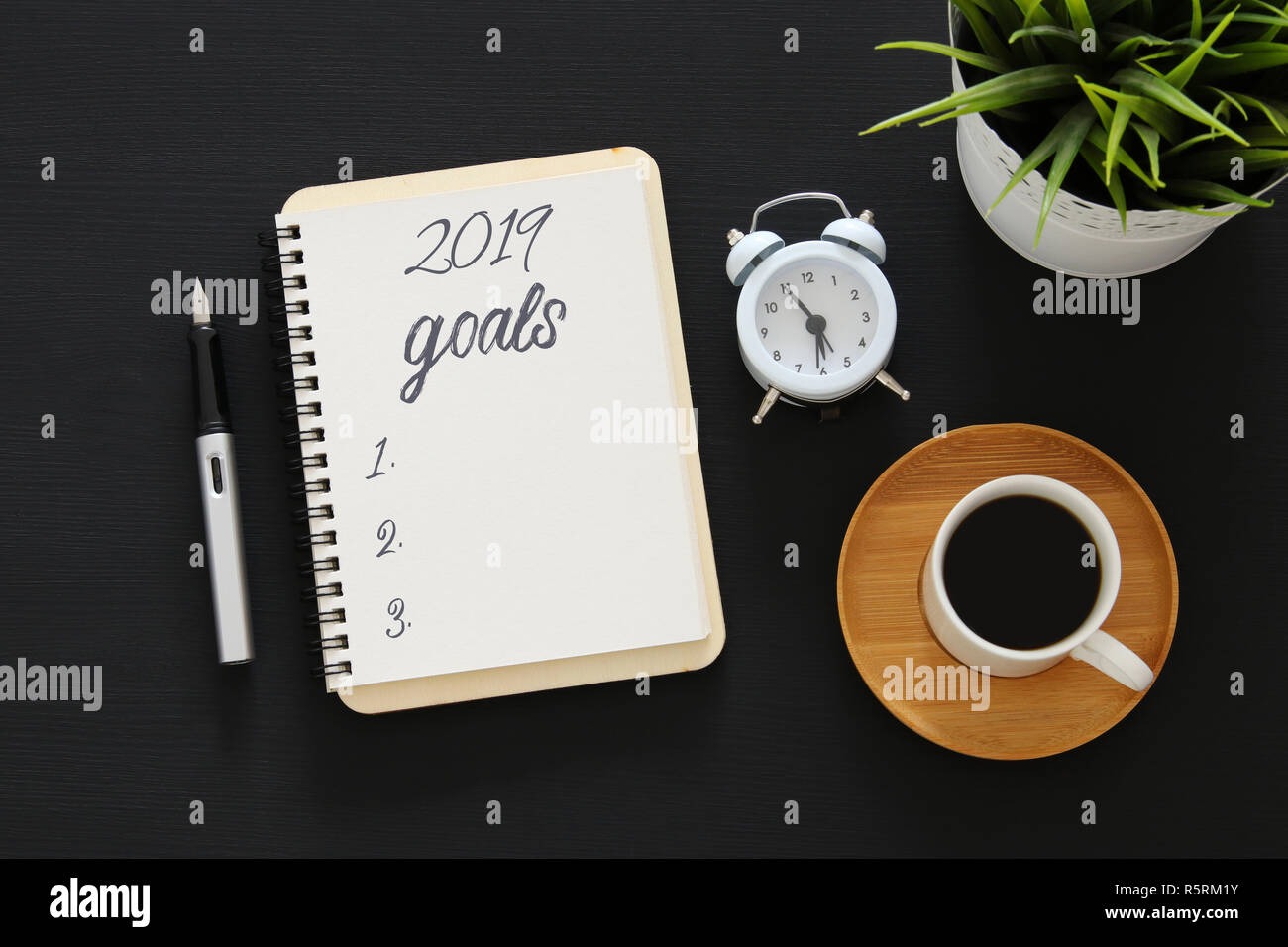 Top view 2019 goals list with notebook, cup of coffee over wooden black ...