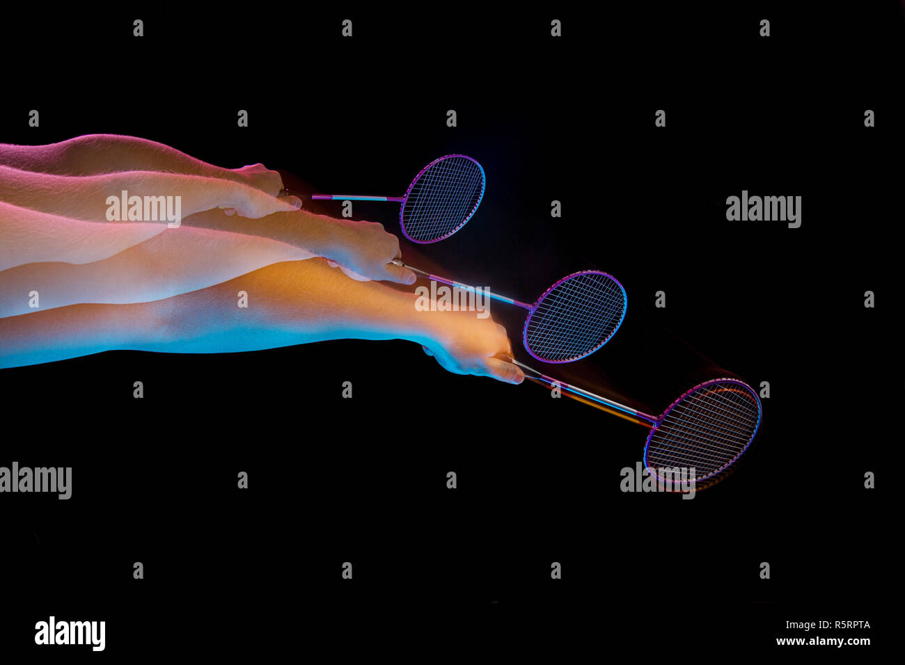 The hands of young man playing badminton over black background Stock ...