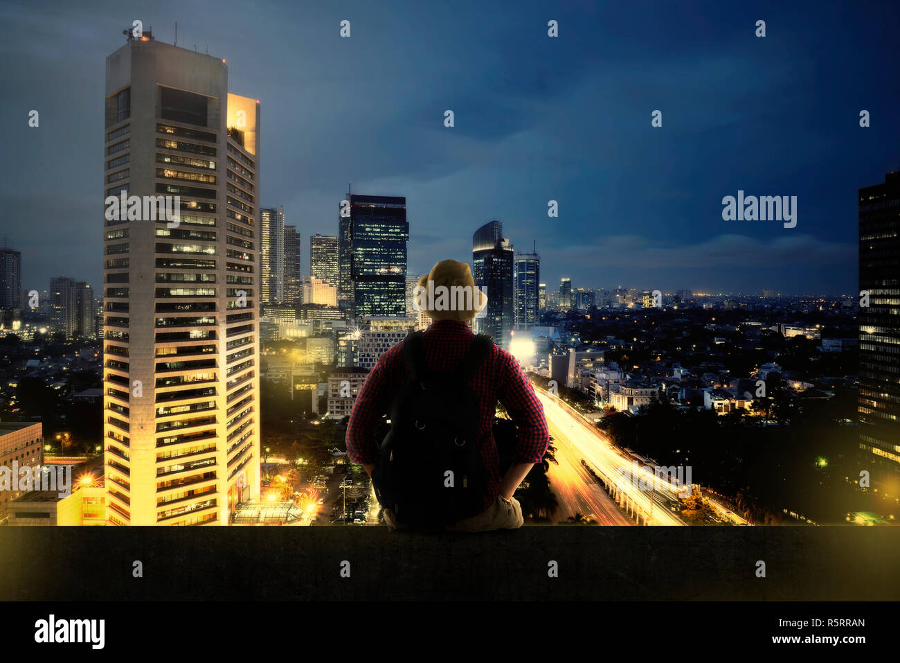 Traveller Sitting On The Top Of Building Stock Photo - Alamy