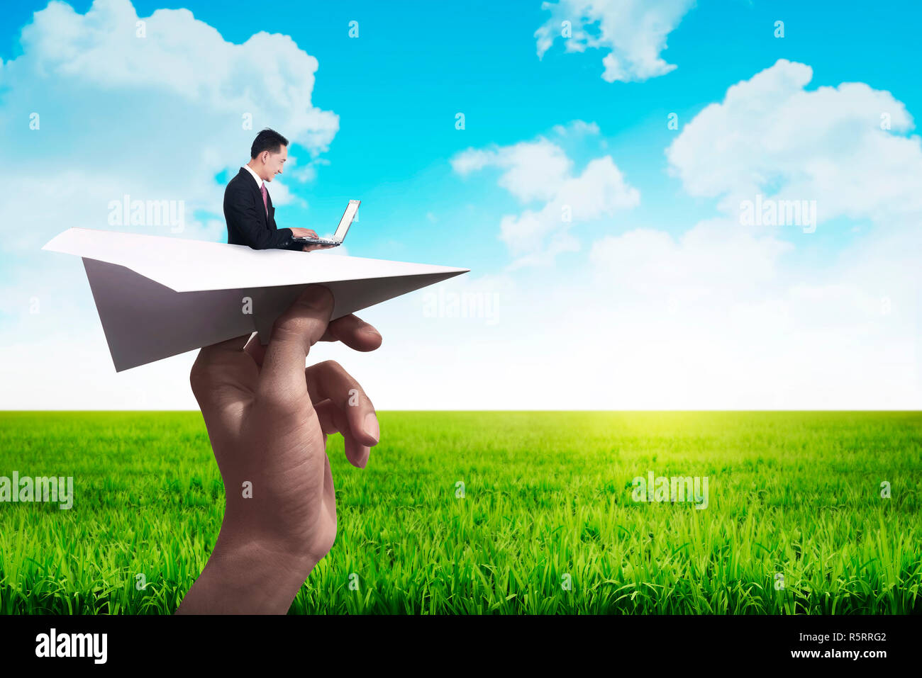 Business man typing with laptop on the paper plane Stock Photo - Alamy