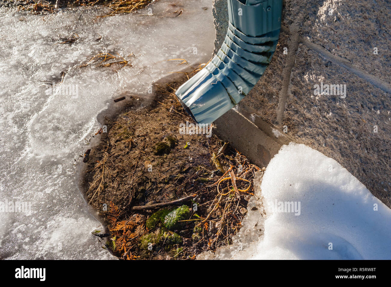Metal pipe dripping water on melting snow Stock Photo - Alamy