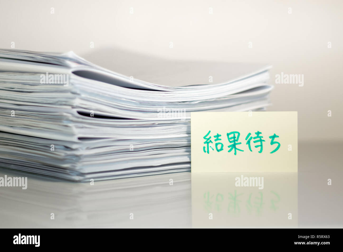 Waiting Result Stack of Documents on white desk and Background Stock ...