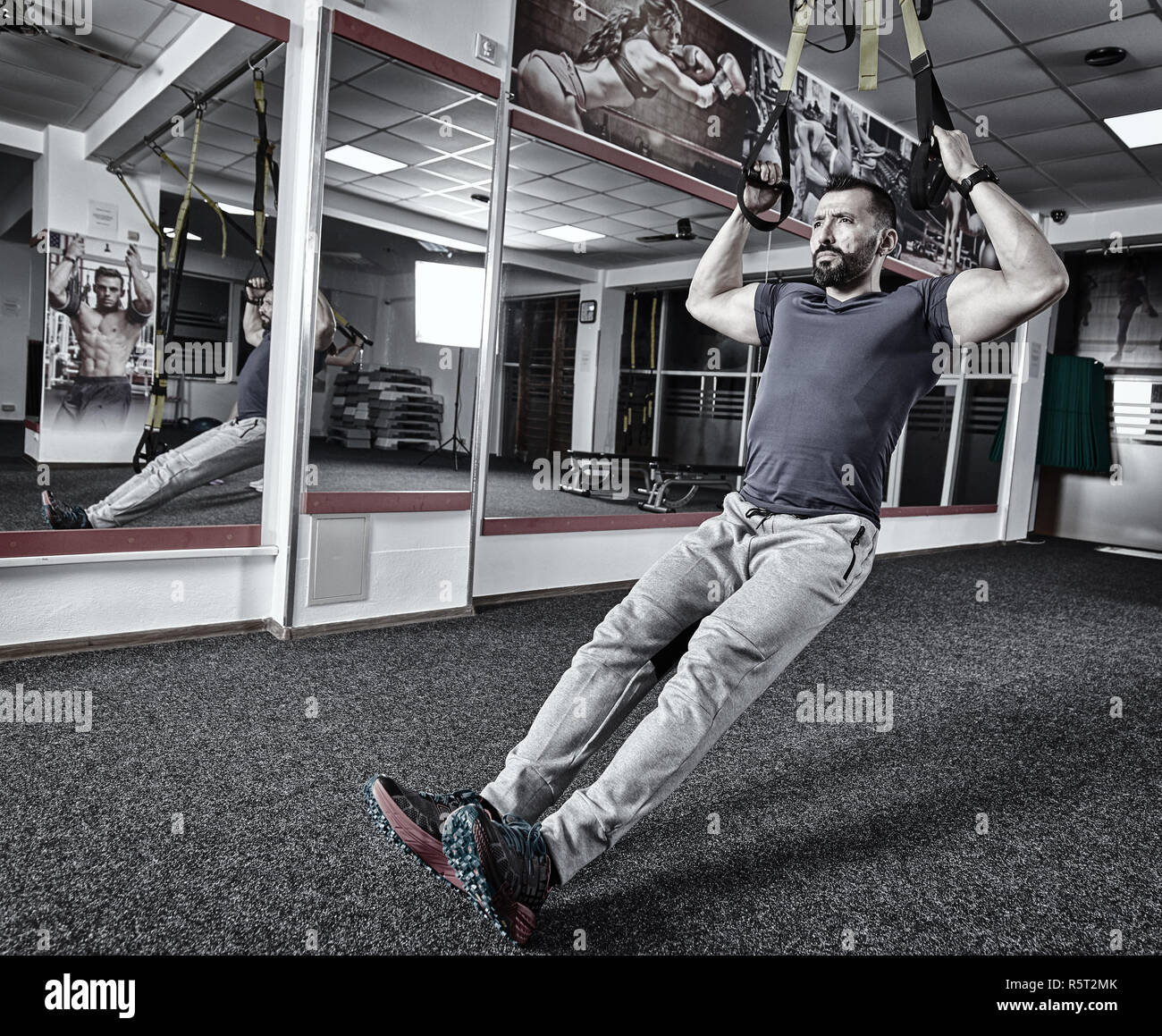 Fit man working with suspension straps in the gym Stock Photo - Alamy