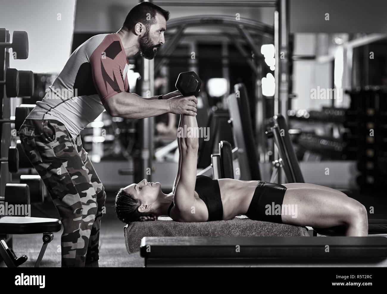Personal fitness trainer assisting a young woman with workout Stock ...