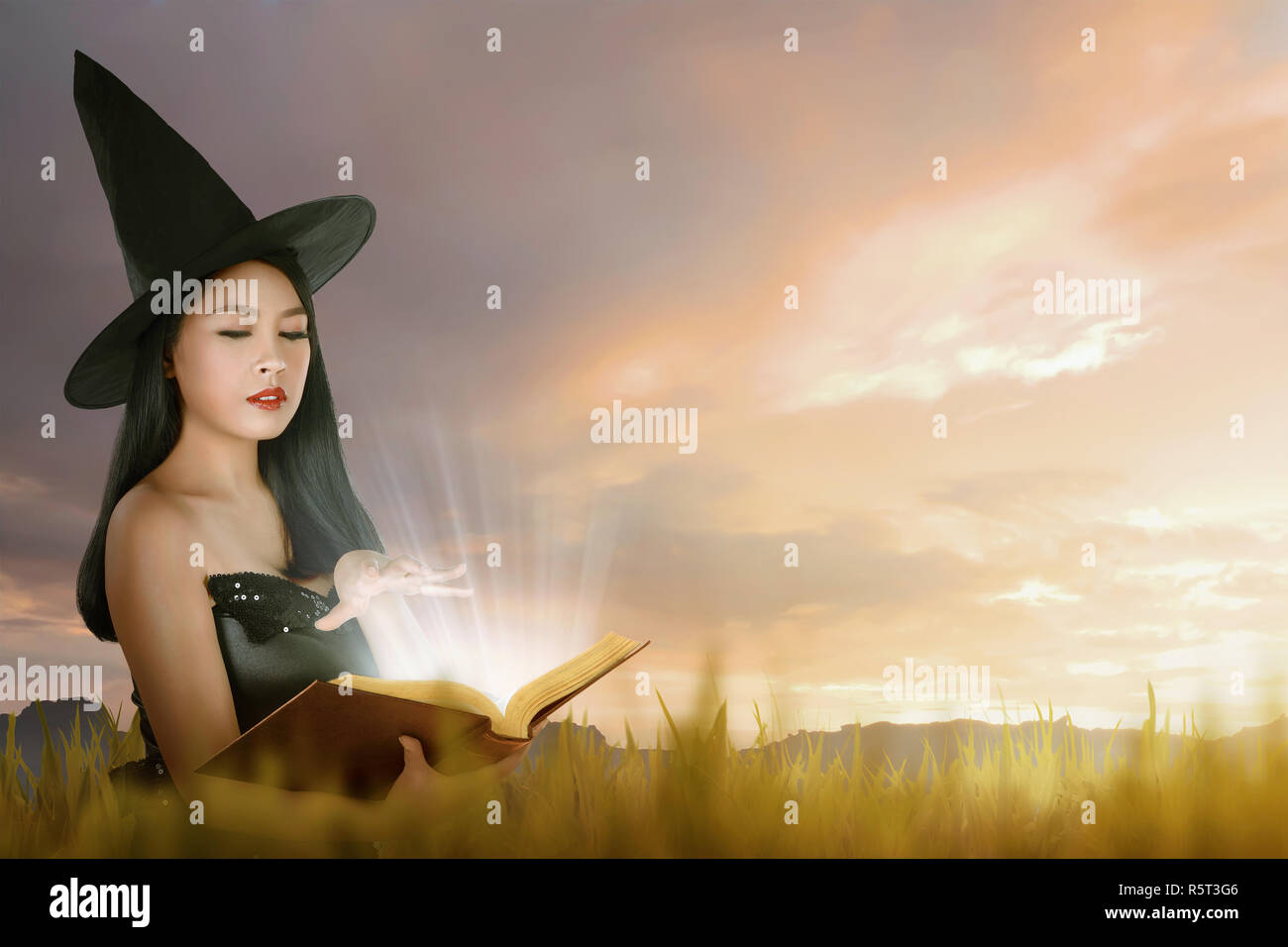Beautiful asian witch woman with hat learning magic from the book Stock ...