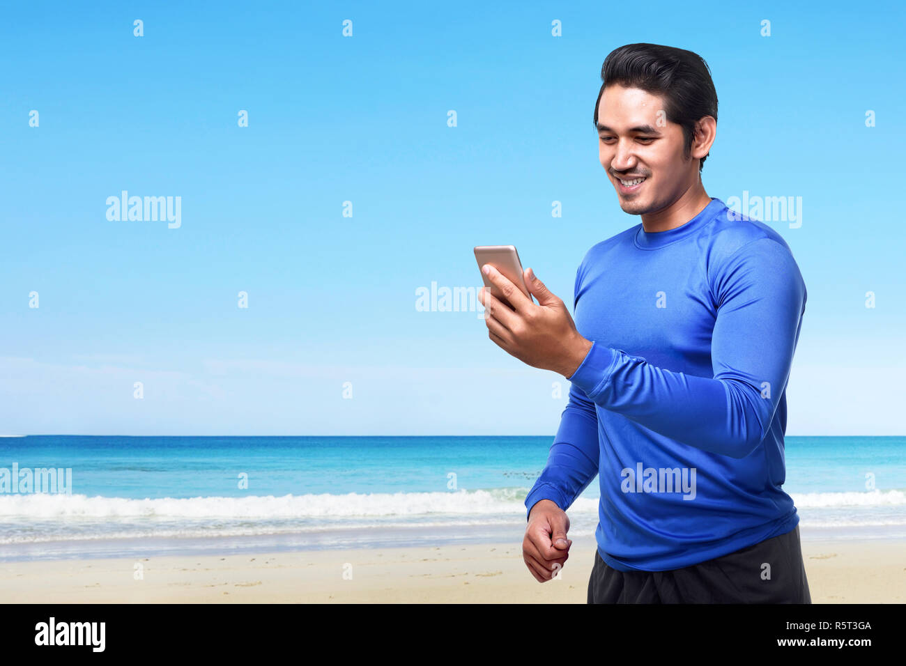 Young asian man using mobile phone before going for a run Stock Photo ...