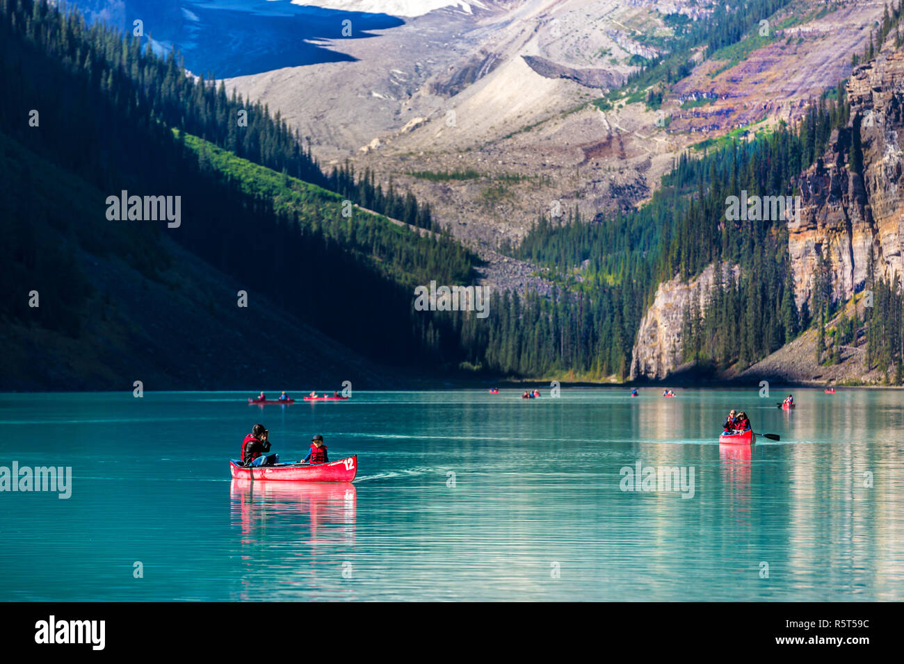 Banff, Canada - Sept 17th 2017 - A family doing kayak at the Lake Louise with pine trees in the ...