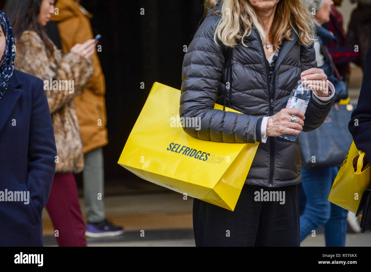 Shoppers carrying Selfridges Department Store paper carrier bags ...