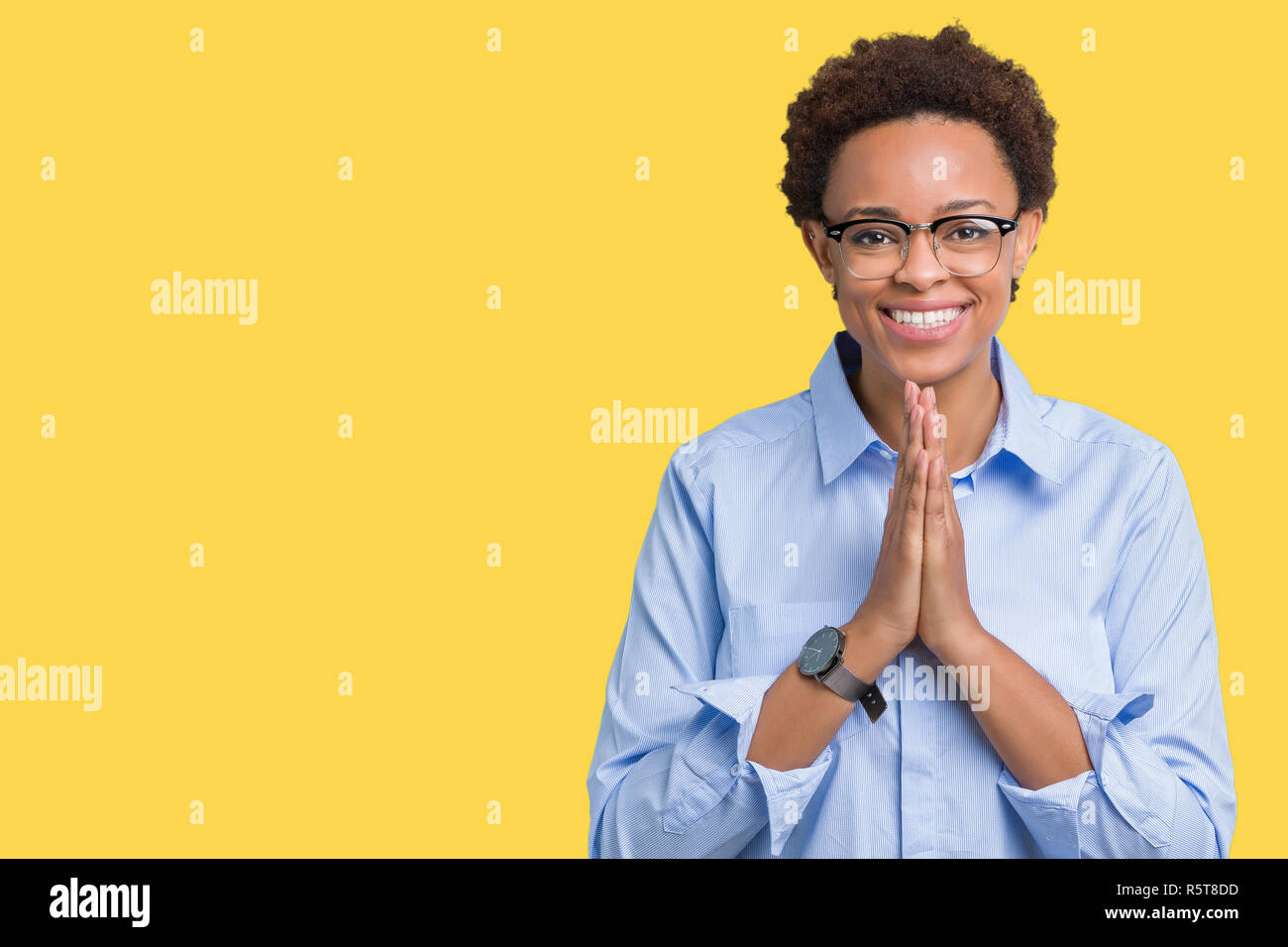 Young beautiful african american business woman over isolated background praying with hands ...