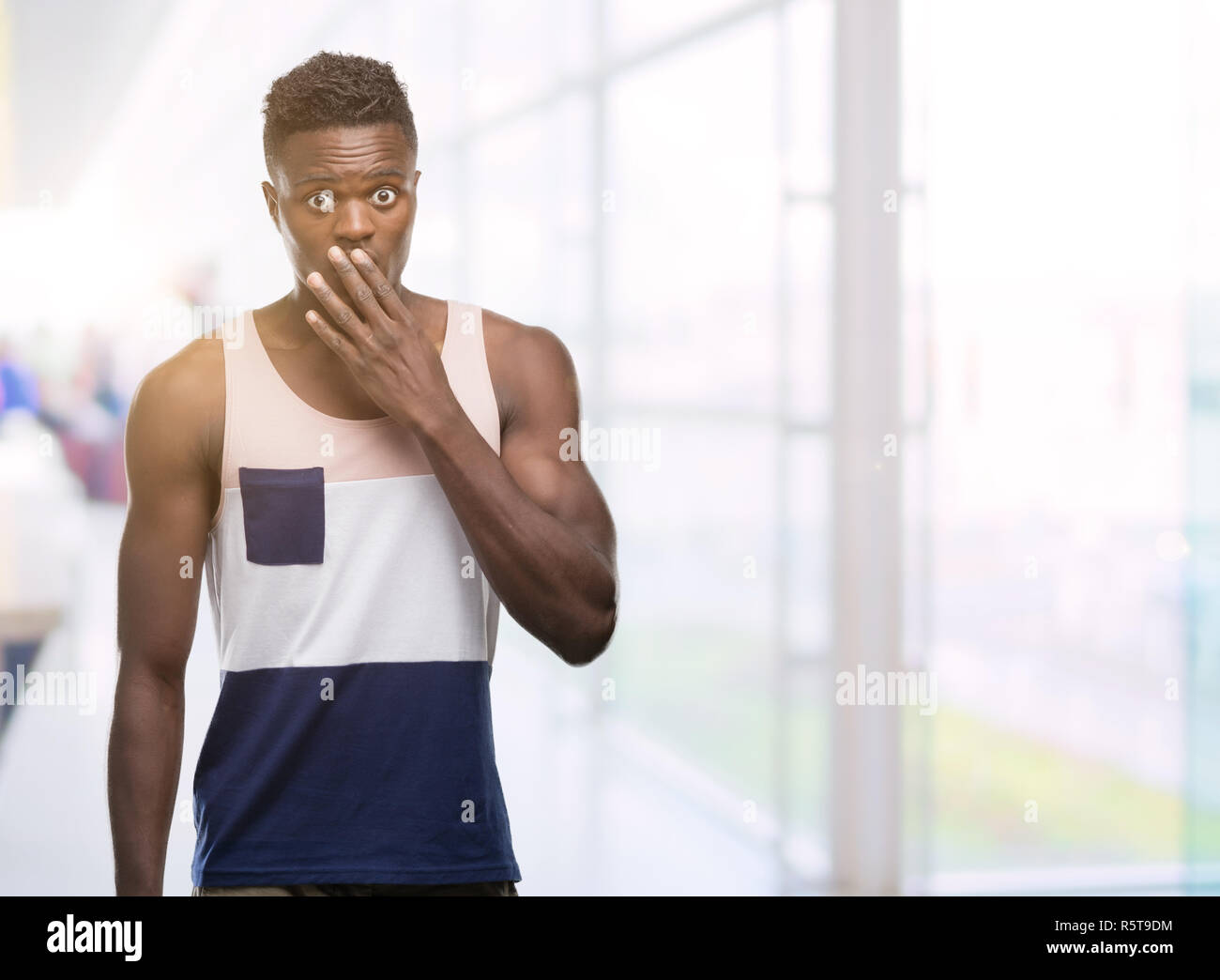 Young african american man cover mouth with hand shocked with shame for ...