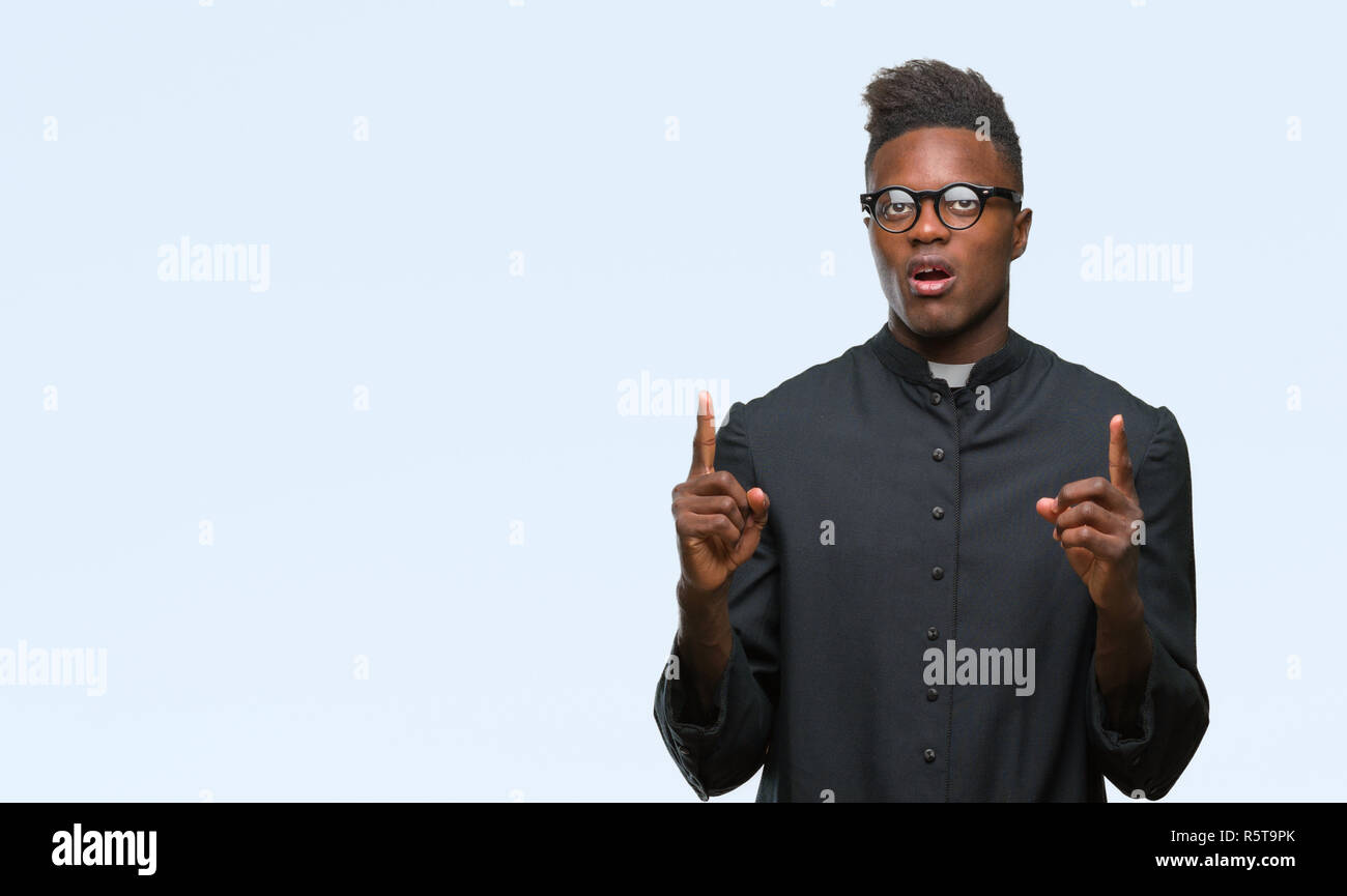 Young african american priest man over isolated background amazed and ...
