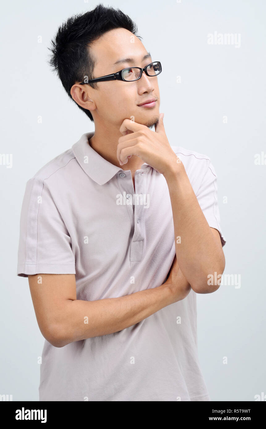 Portrait of casual Asian man thinking Stock Photo - Alamy