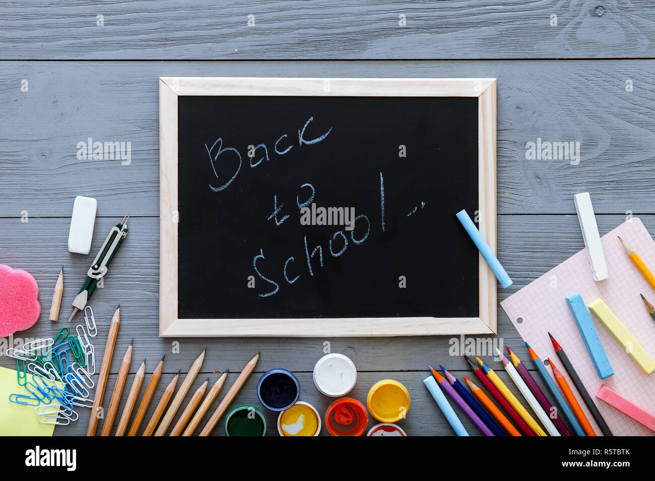 Kids supplies on on grey wooden desk, back to school background written ...