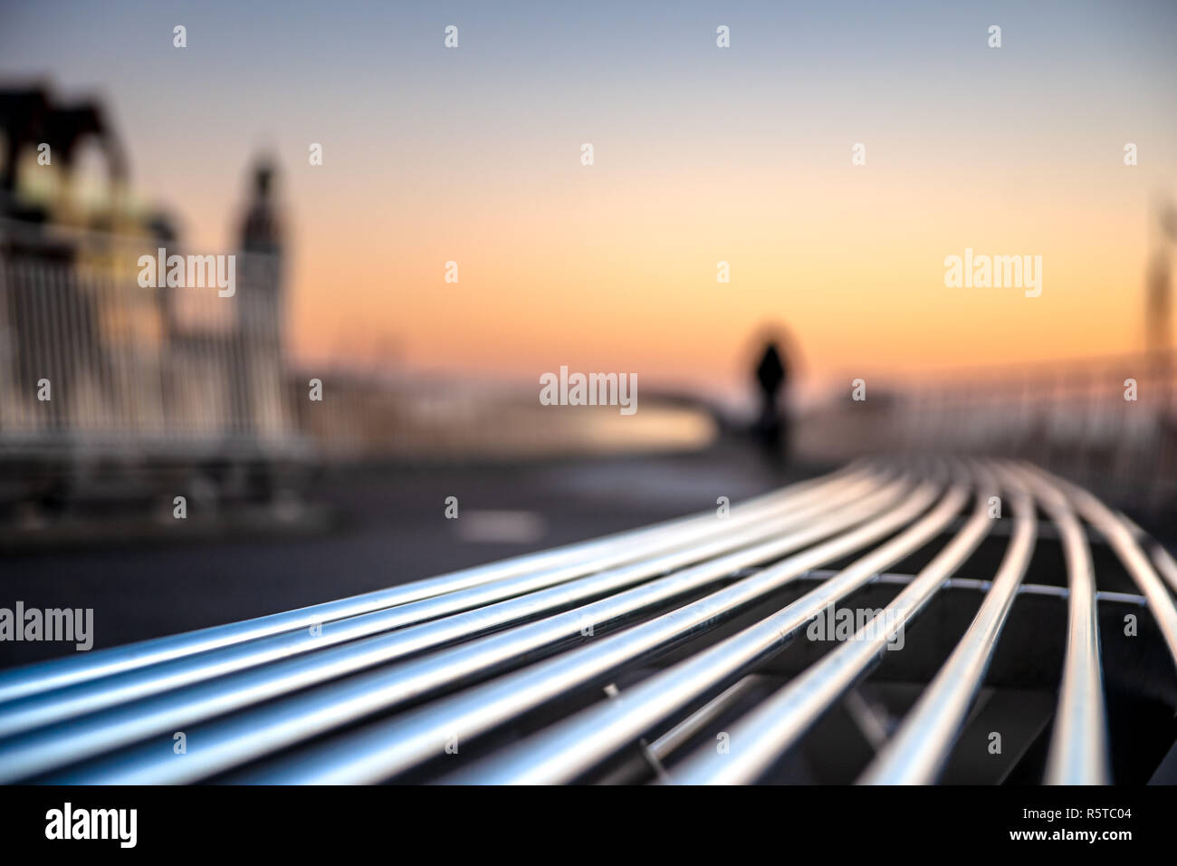 Modern empty iron bench with curved shapes along a boulevard or in a ...