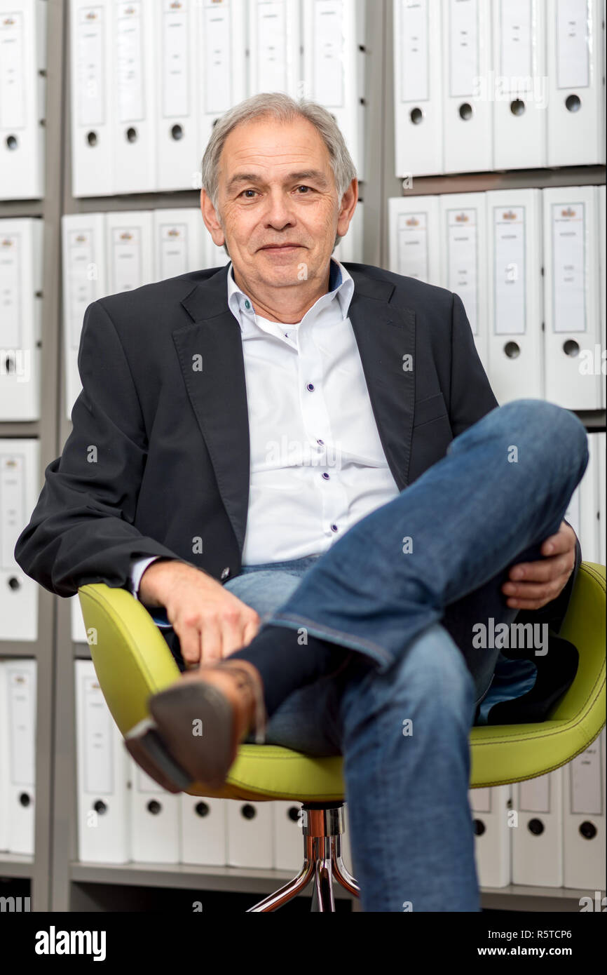 senior man in suit in front of a shelf wall with documents folder Stock ...