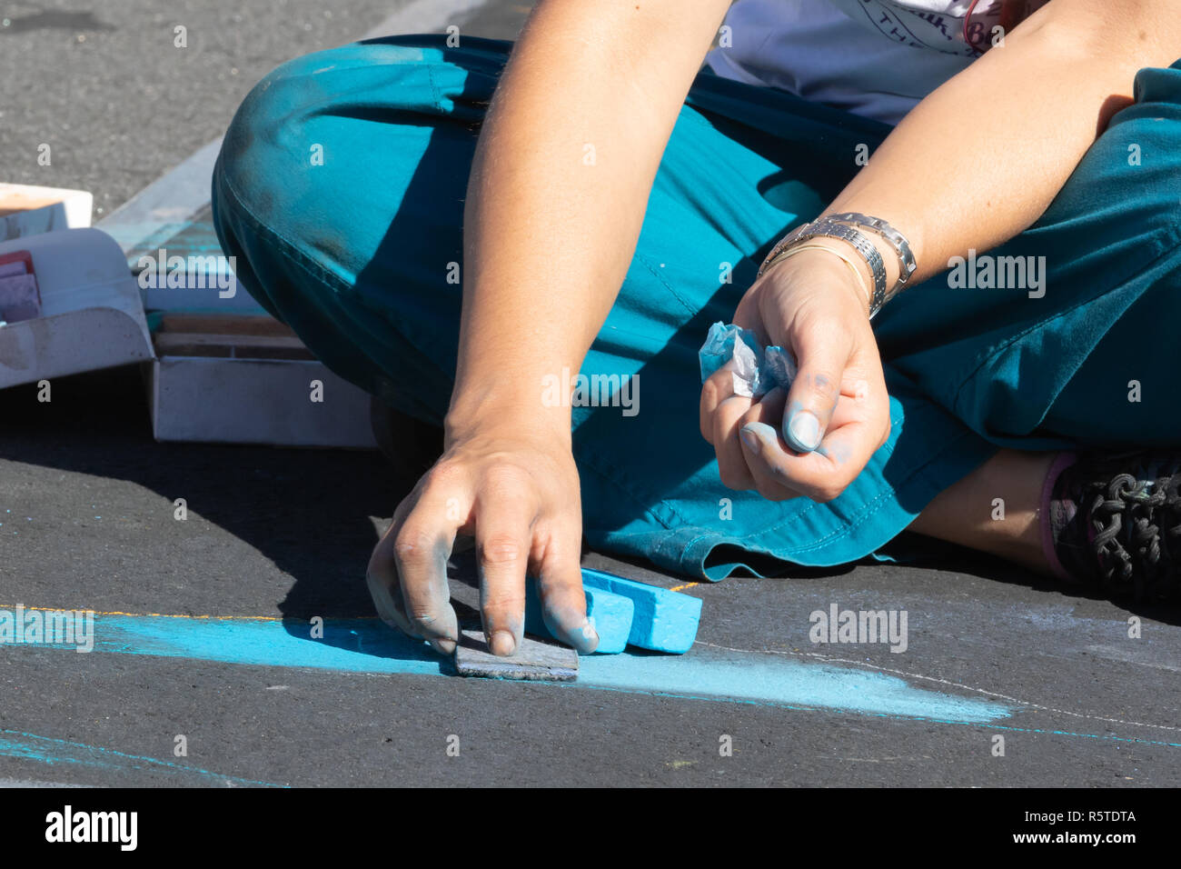 Street artist using chalk to draw on the pavement Stock Photo - Alamy