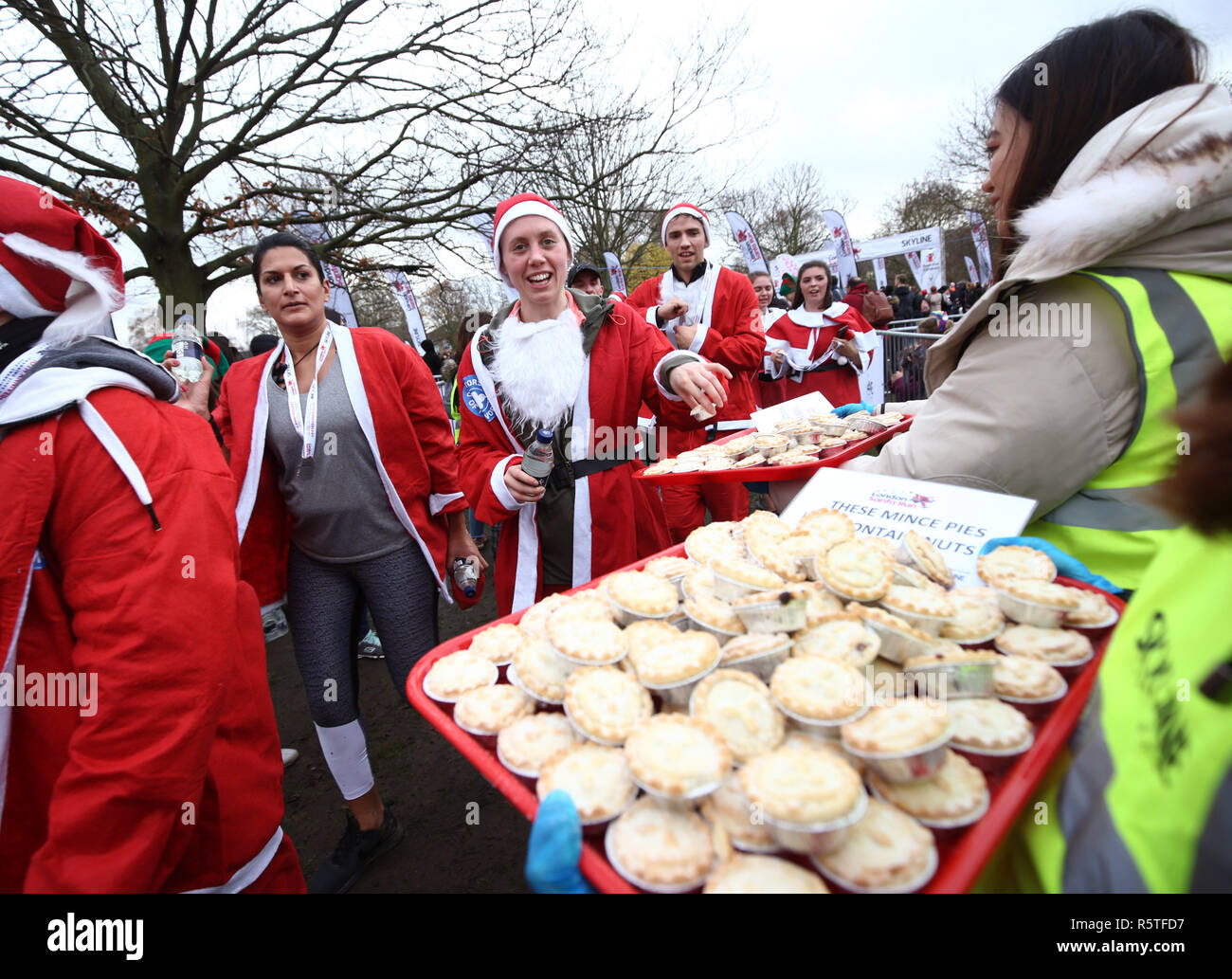 Participants take some mince pies after taking part in the London Santa ...
