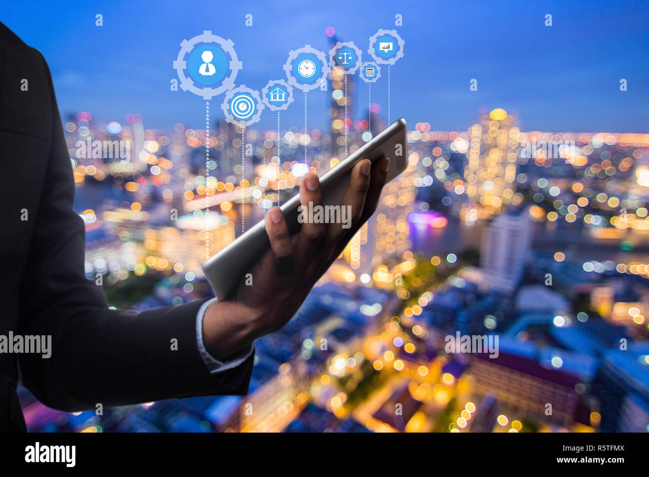 business and technology concept, businessman holding tablet on night ...
