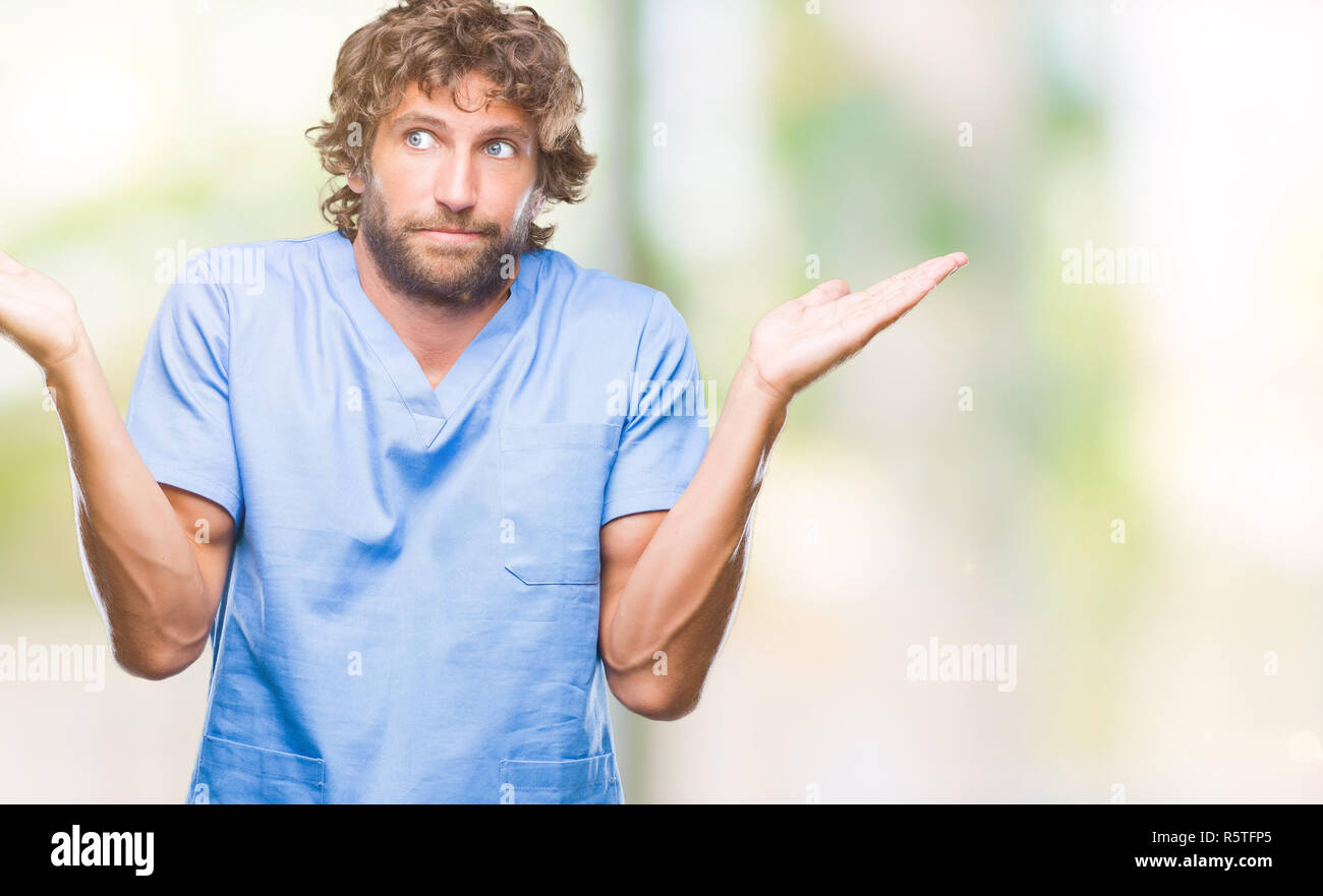 Handsome hispanic surgeon doctor man over isolated background clueless ...