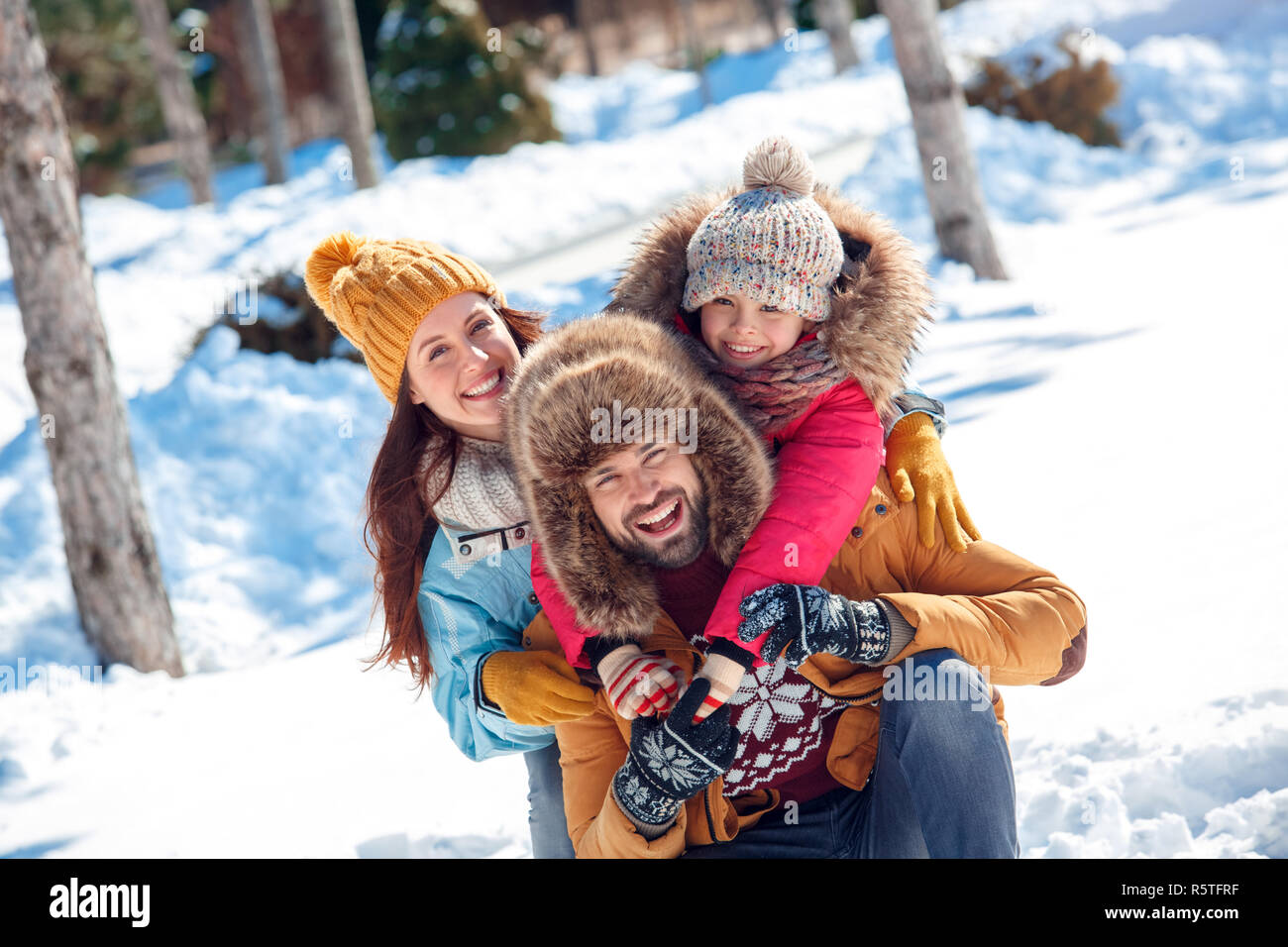 Winter vacation. Family time together outdoors sitting hugging laughing ...