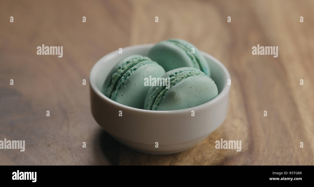 light blue macarons in white bowl on wood table Stock Photo - Alamy