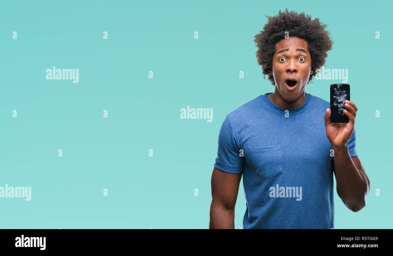 Afro american man holding broken smartphone over isolated background ...
