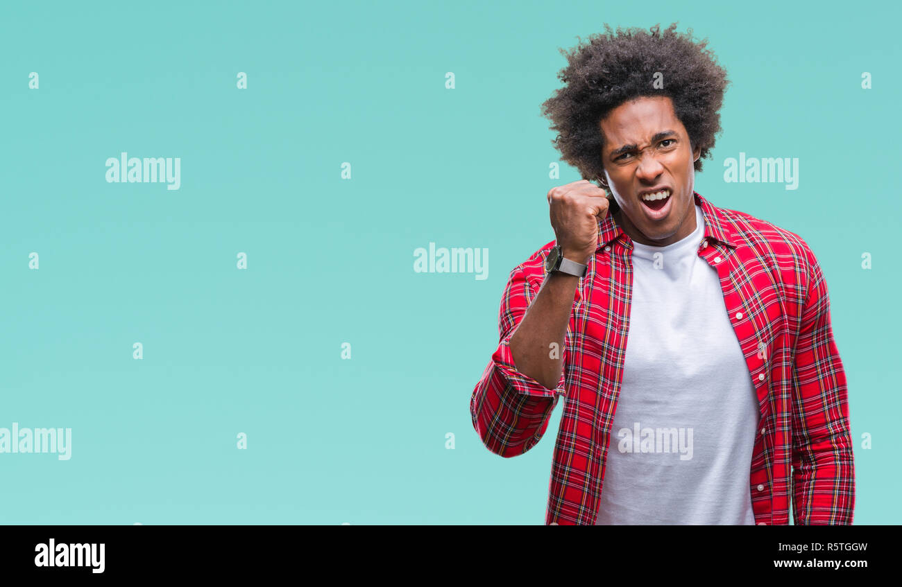 Afro american man over isolated background angry and mad raising fist ...