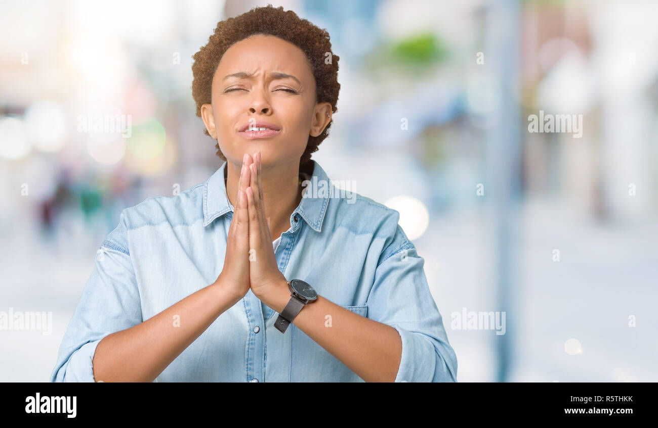 Young beautiful african american woman over isolated background begging ...