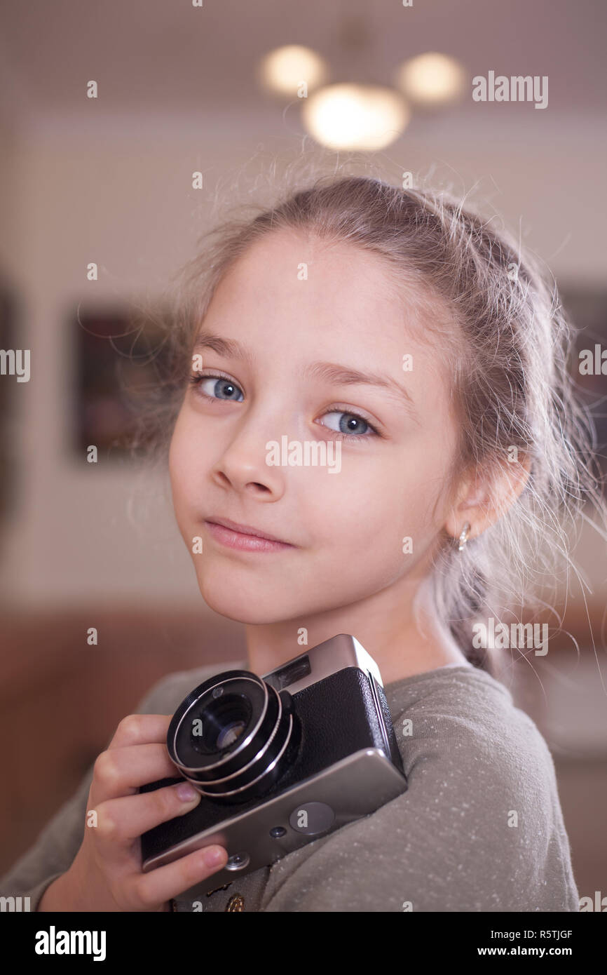 Girl with a retro camera makes a photo, studio shot Stock Photo - Alamy