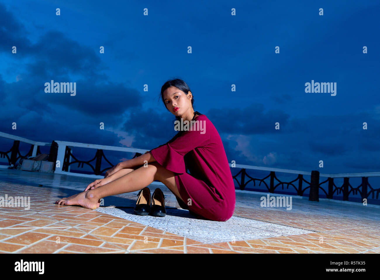Beautiful woman posing - sitting on roof, looking at camera Stock Photo ...