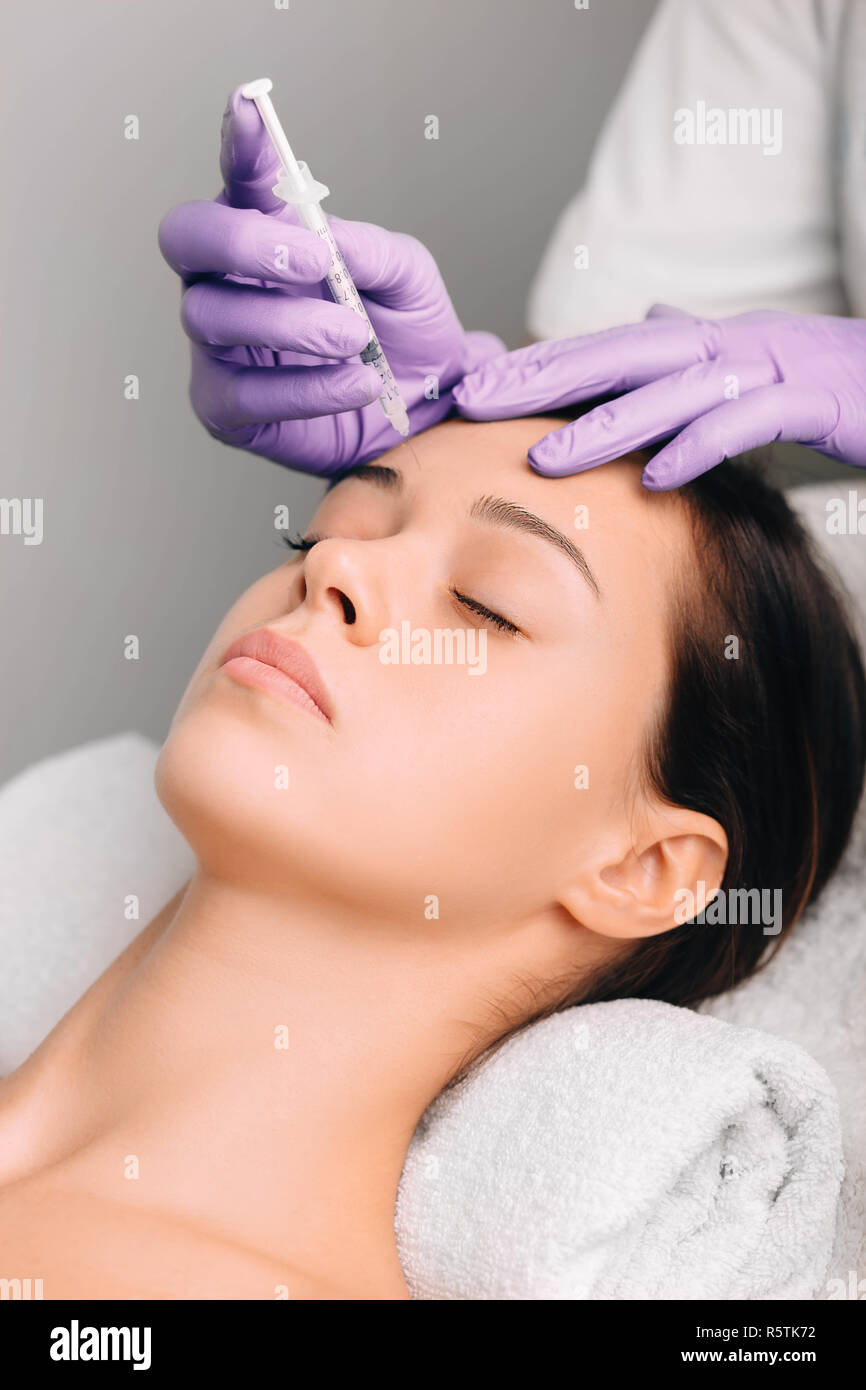 woman having facial injections for facelift and anti-aging effect ...