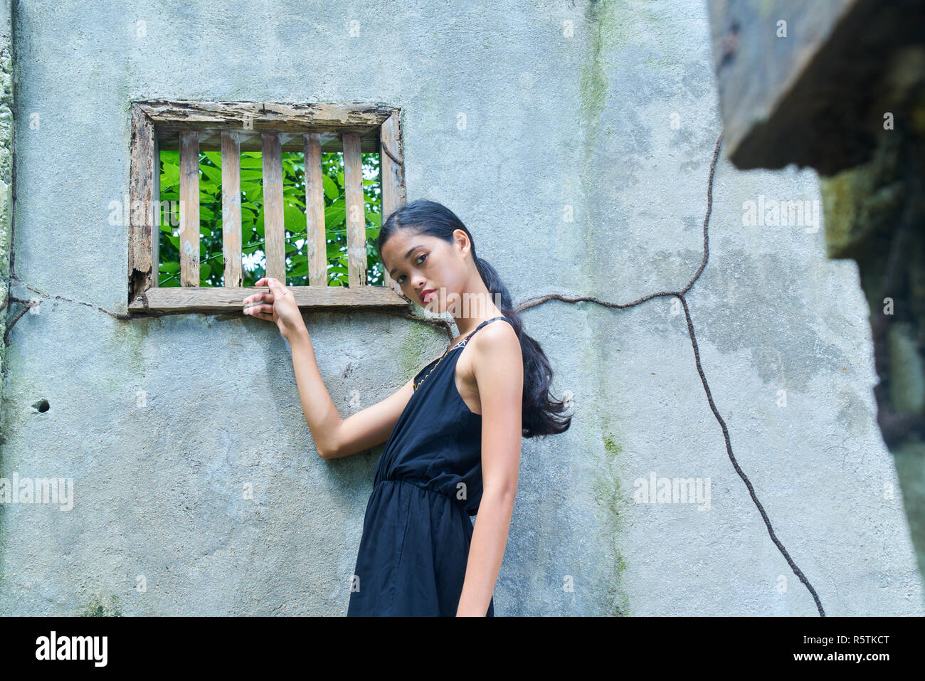 Beautiful woman posing - standing on the wall, side view Stock Photo ...