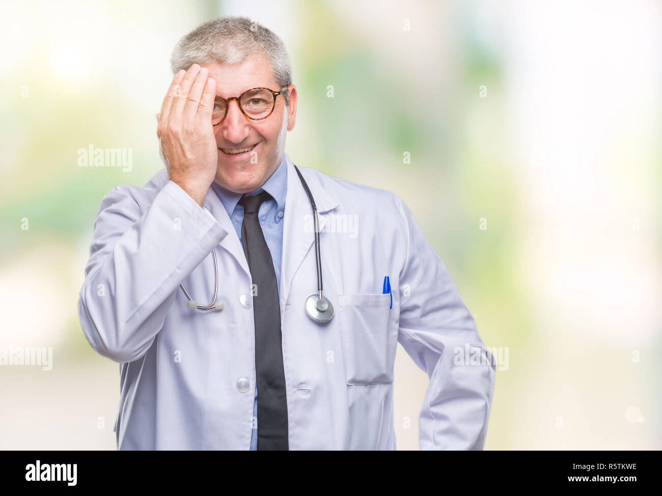 Handsome senior doctor man over isolated background covering one eye ...