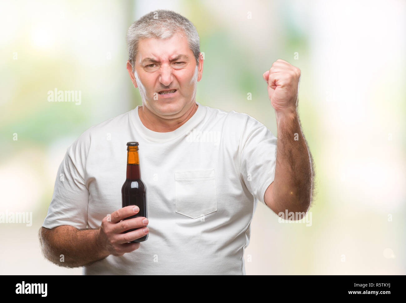 Handsome senior man drinking beer bottle over isolated background ...