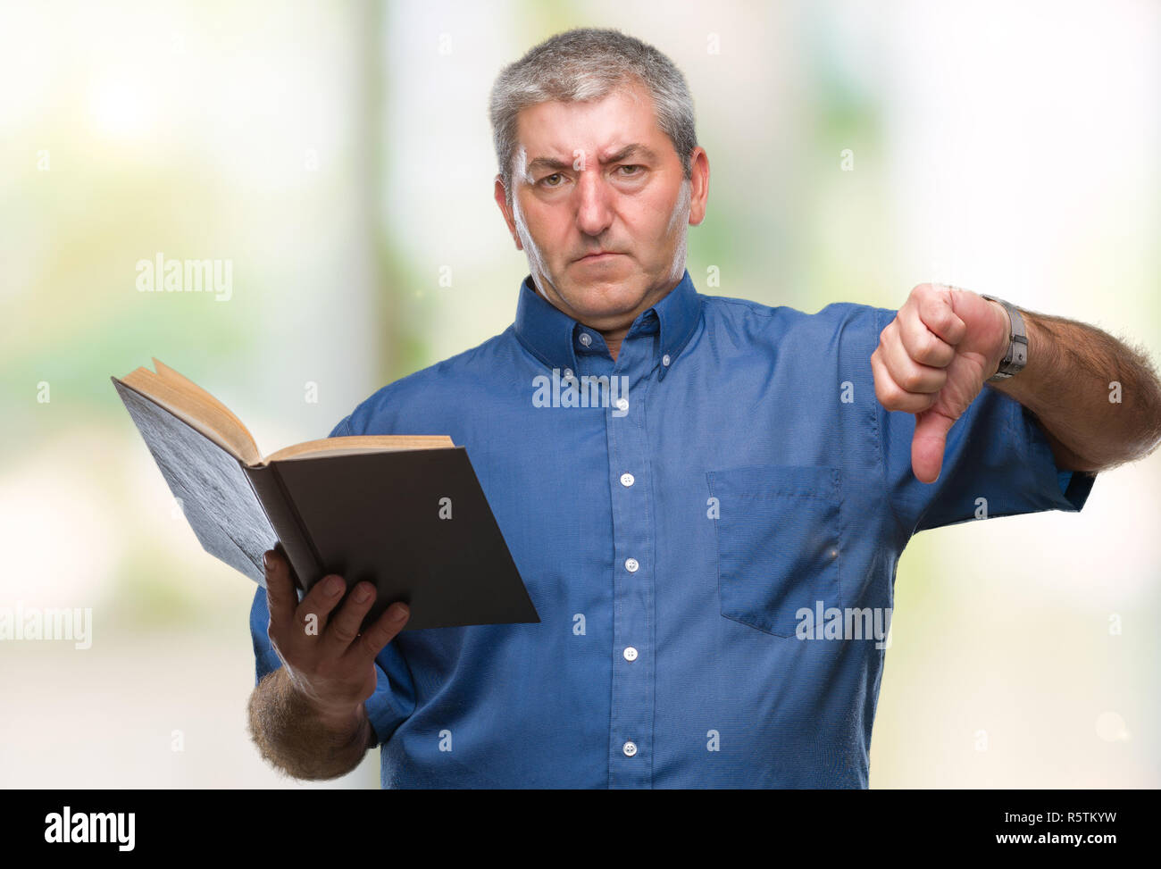 Handsome senior teacher man reading a book over isolated background ...