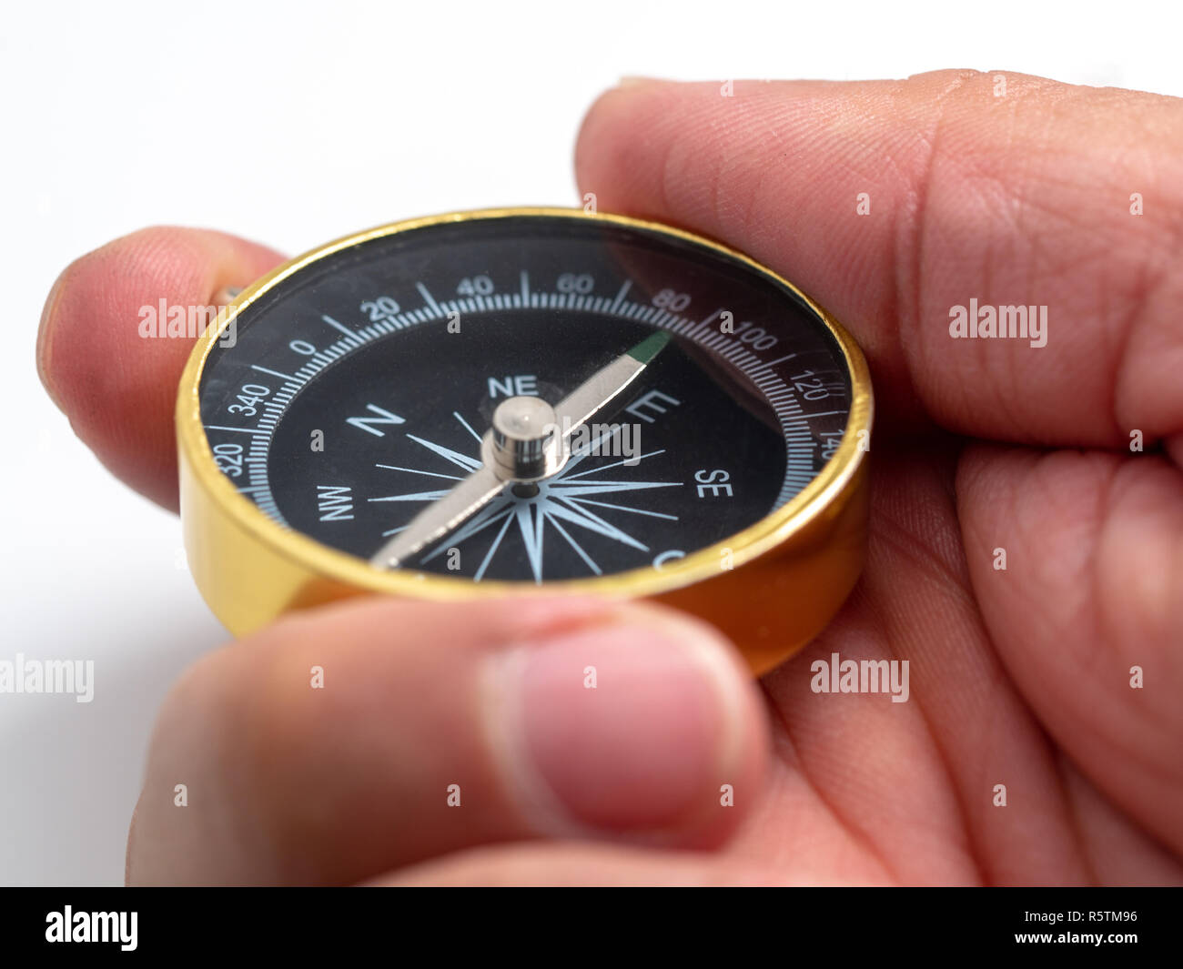 closeup man hand holding golden compass on white background (Isolated ...