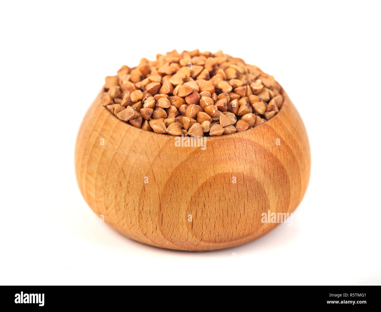 Roasted buckwheat grains in wooden bowl isolated on white background ...