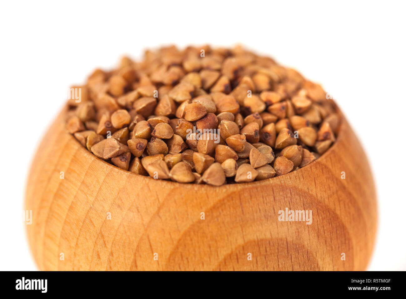 Roasted buckwheat grains in wooden bowl isolated on white background ...