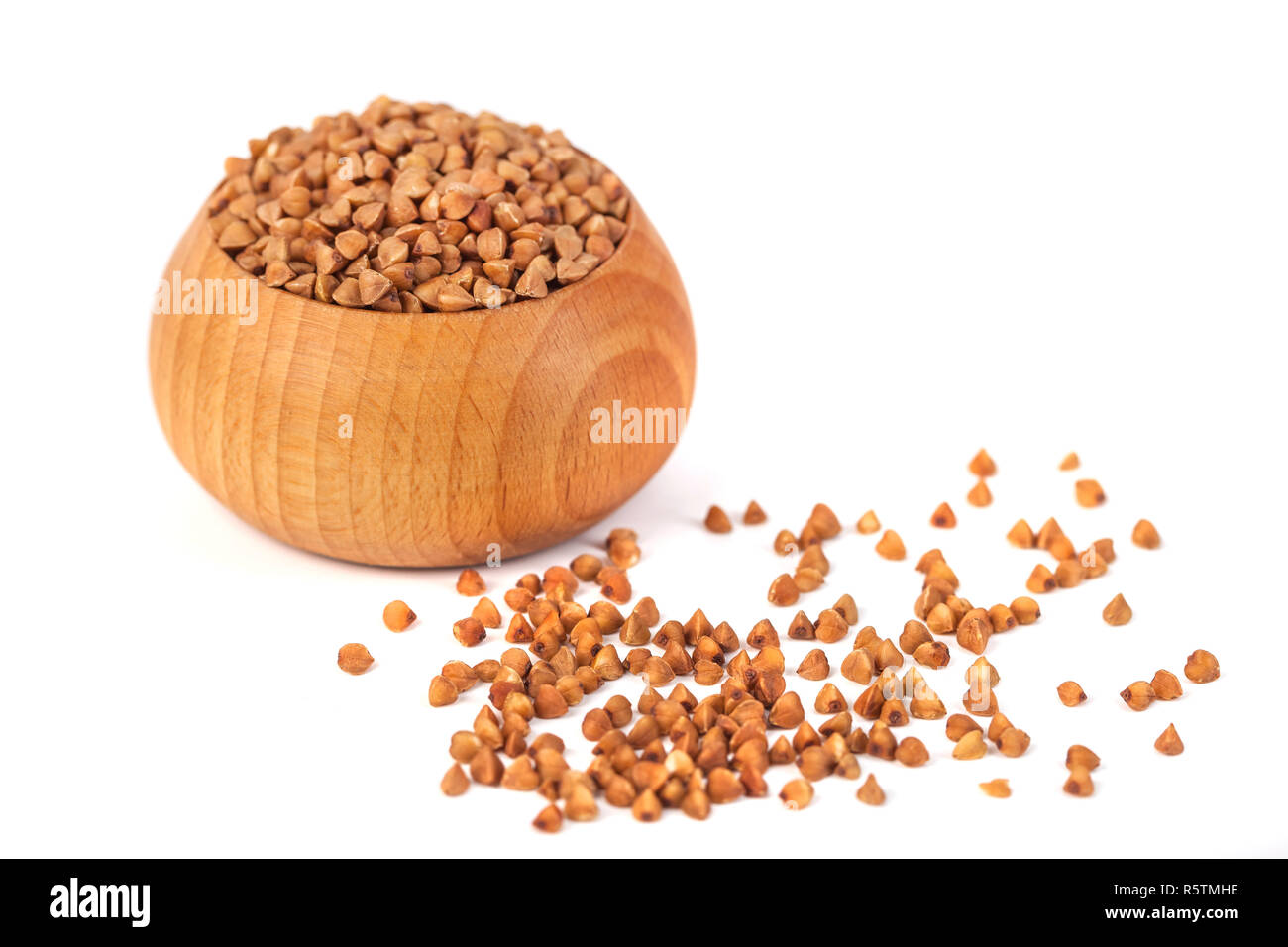Roasted buckwheat grains in wooden bowl isolated on white background ...